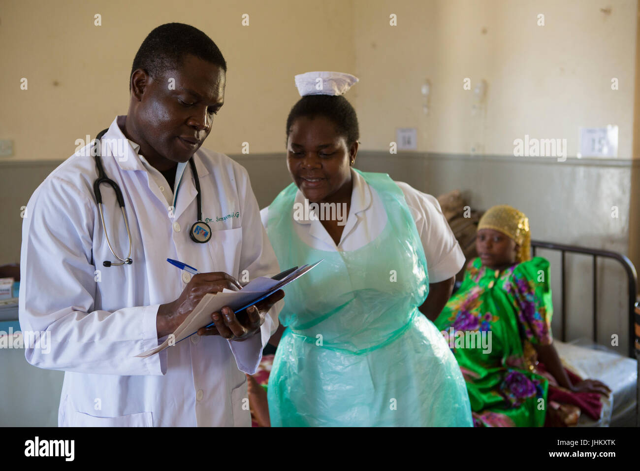 A doctor checking a patients notes on the ward at a regional referral ...