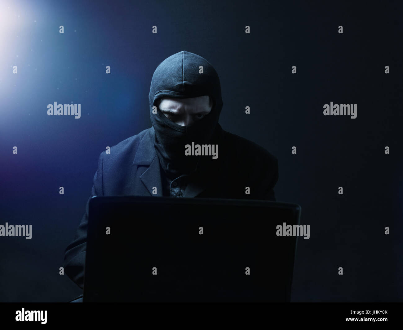 Angry computer hacker in suit stealing data from laptop in front of ...