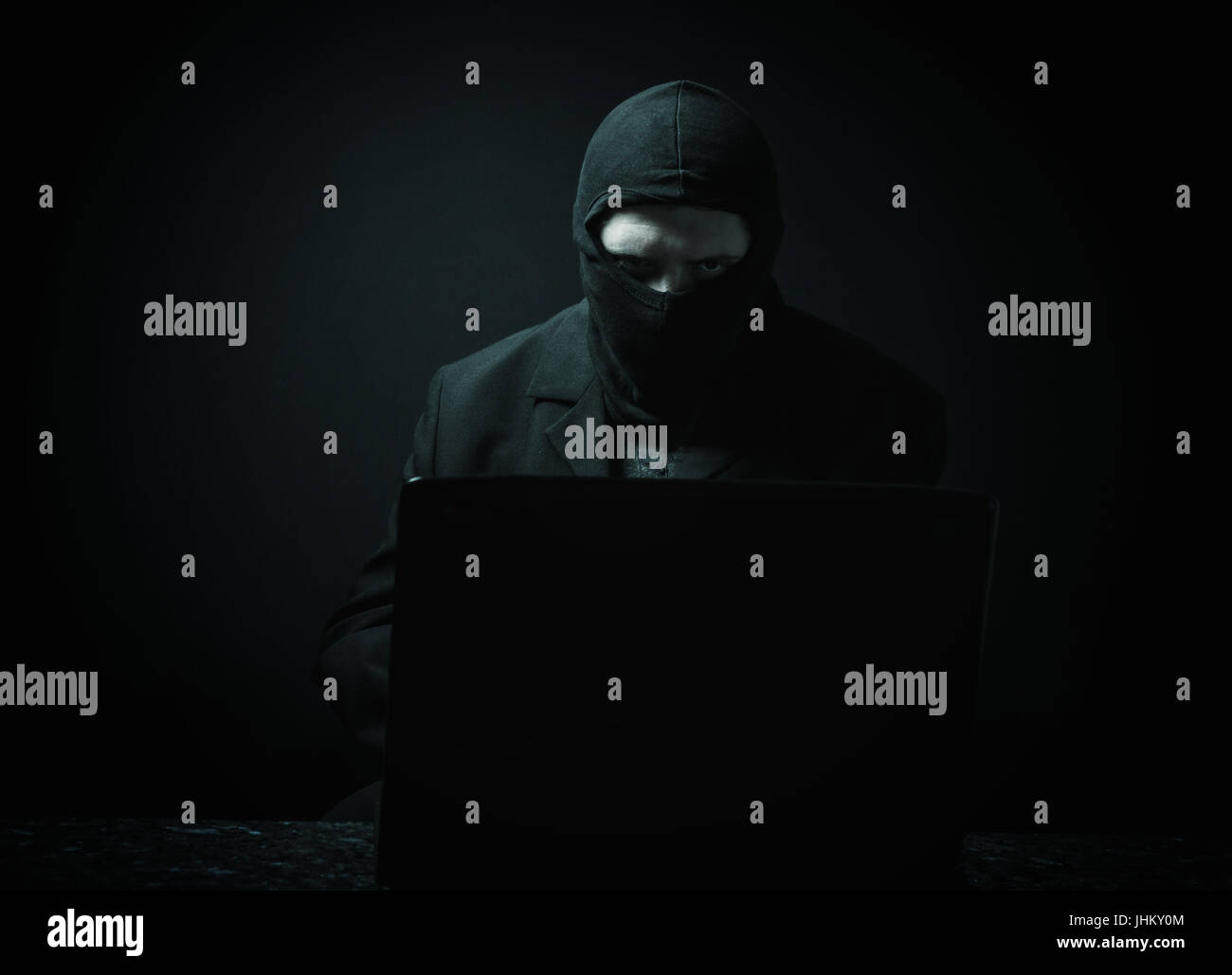 Angry business man as computer hacker in suit stealing data from laptop ...