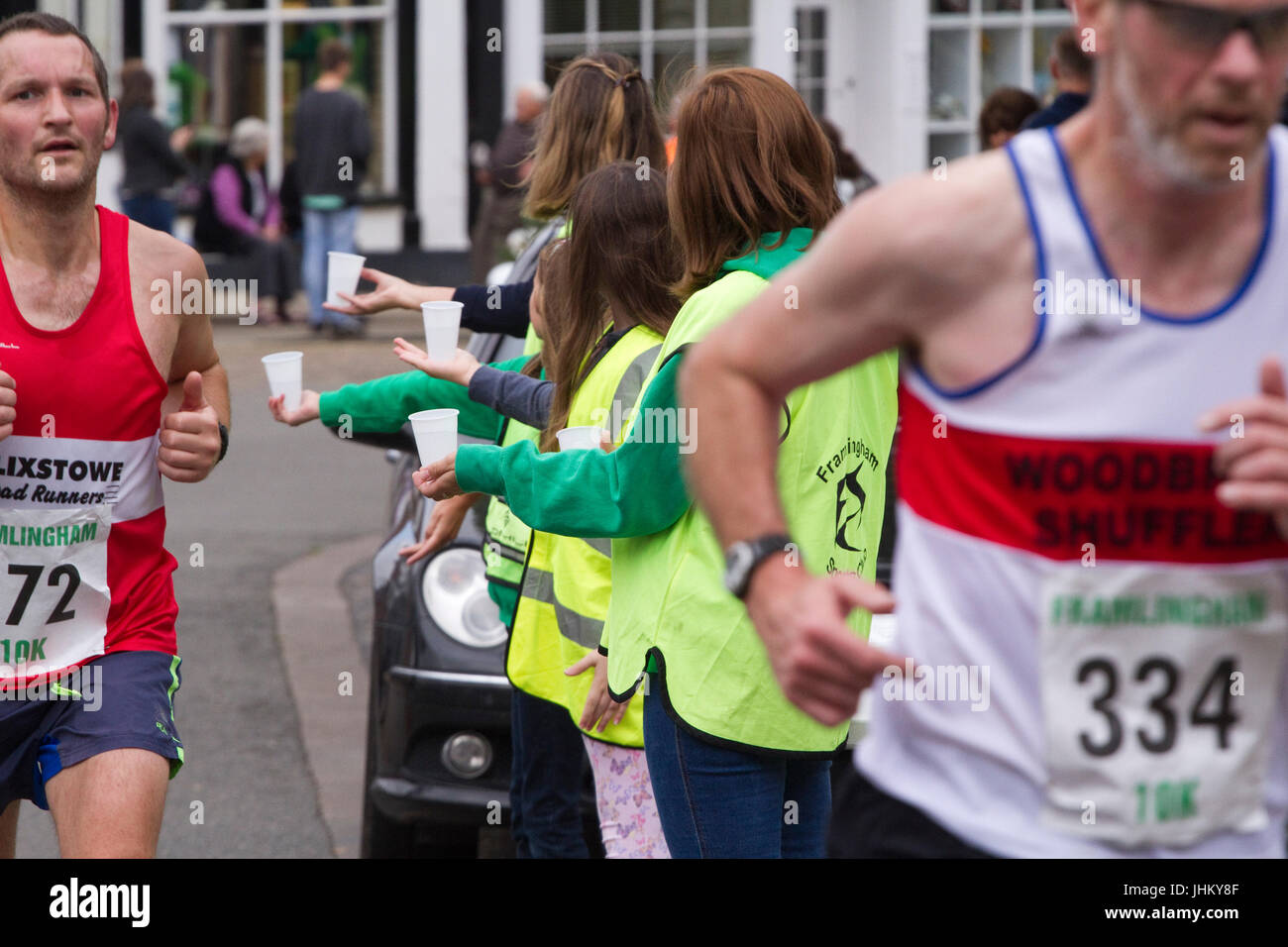 Young women handing up water to road runners Stock Photo - Alamy