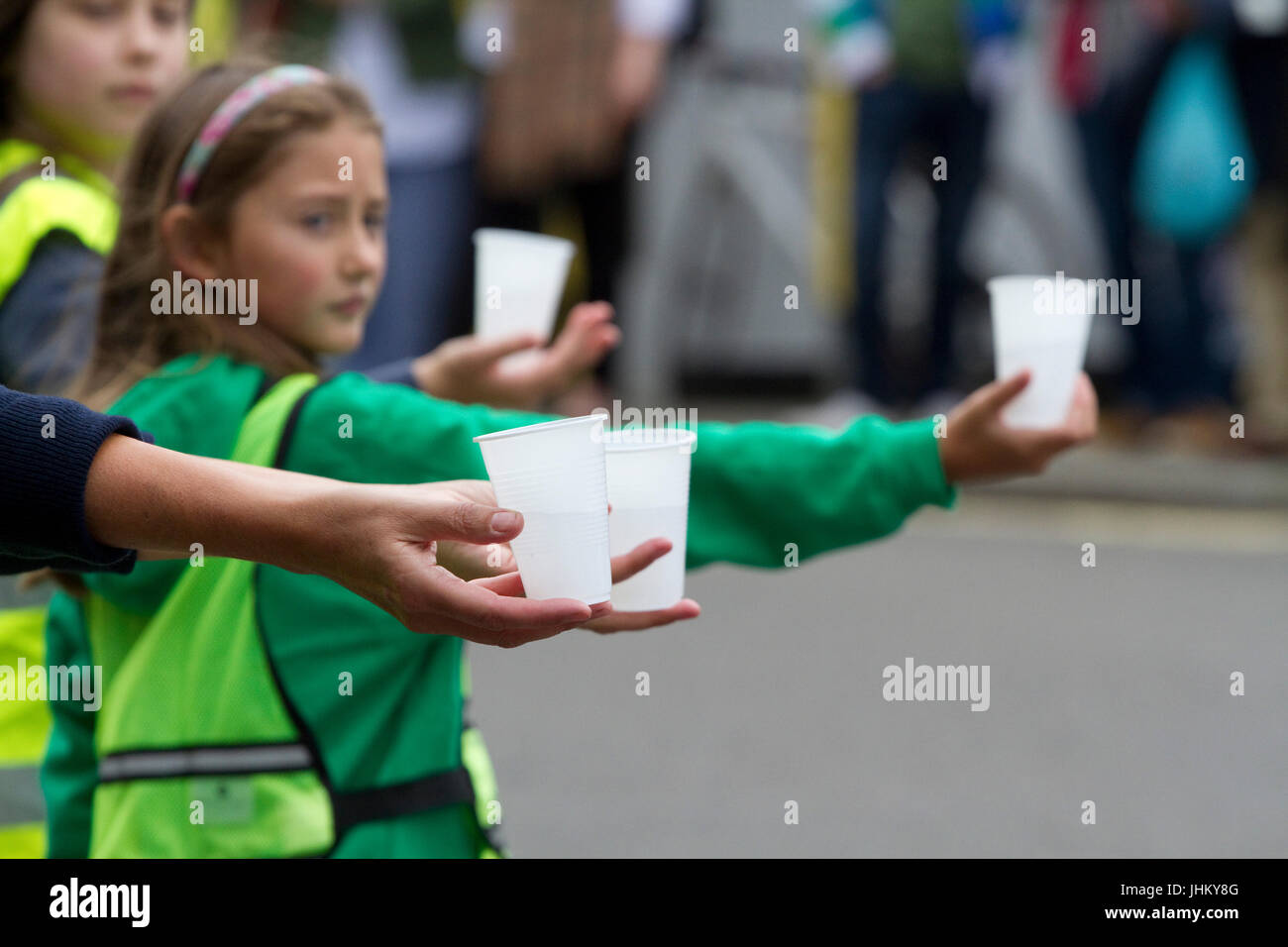 Young women handing up water to road runners Stock Photo - Alamy