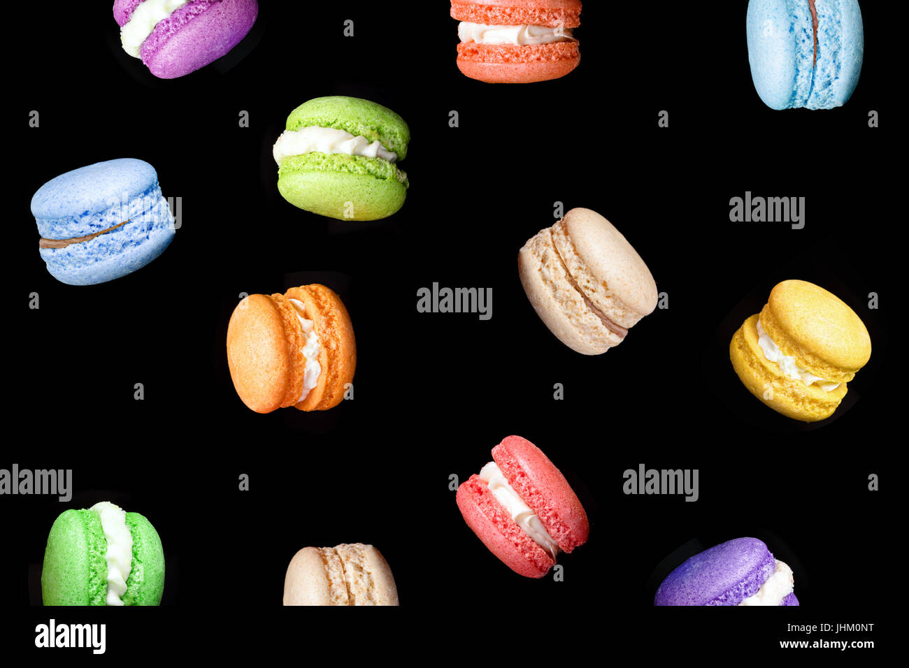Multicolored macaroons isolated on black background falling or flying ...
