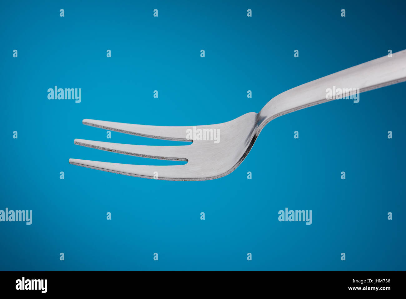 Fork in Blue Background Stock Photo - Alamy