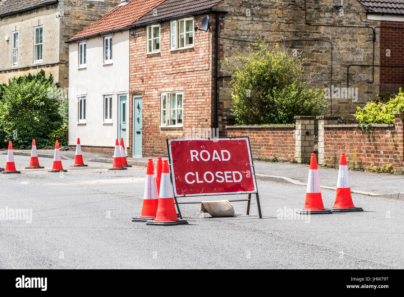 Road Closed sign with cones around newly laid Tarmac, on a village road ...