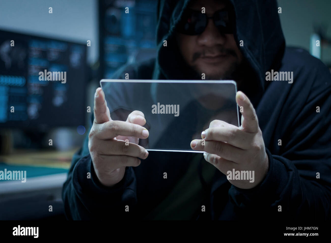 Hacker using blank clear glass tablet with blue dark and grain process ...