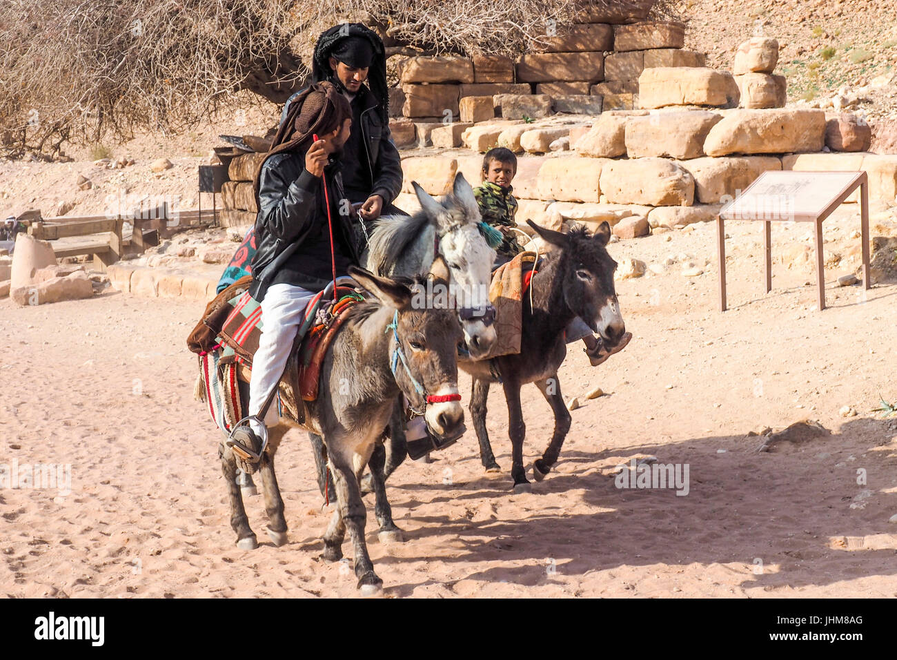 A Bedouin horseman and child riding donkeys in Petra, Jordan Stock ...