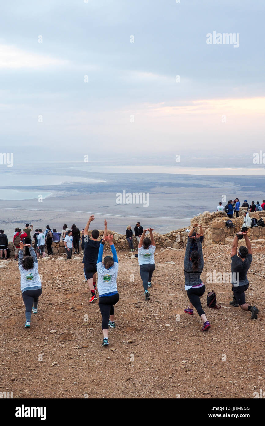 Group of people doing yoga exercises on top of Mount Masada, Israel ...
