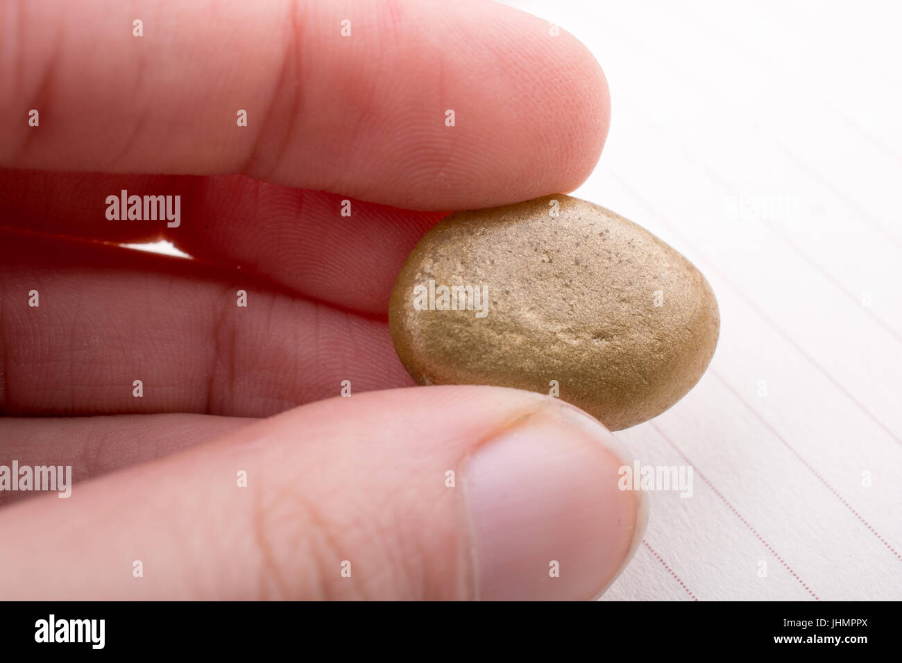 Little gold color pebble in the hand Stock Photo - Alamy