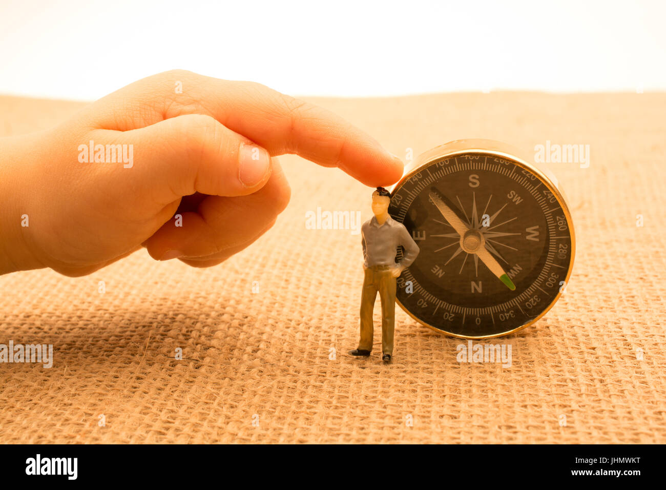 Figurine man beside of a compass on canvas Stock Photo - Alamy