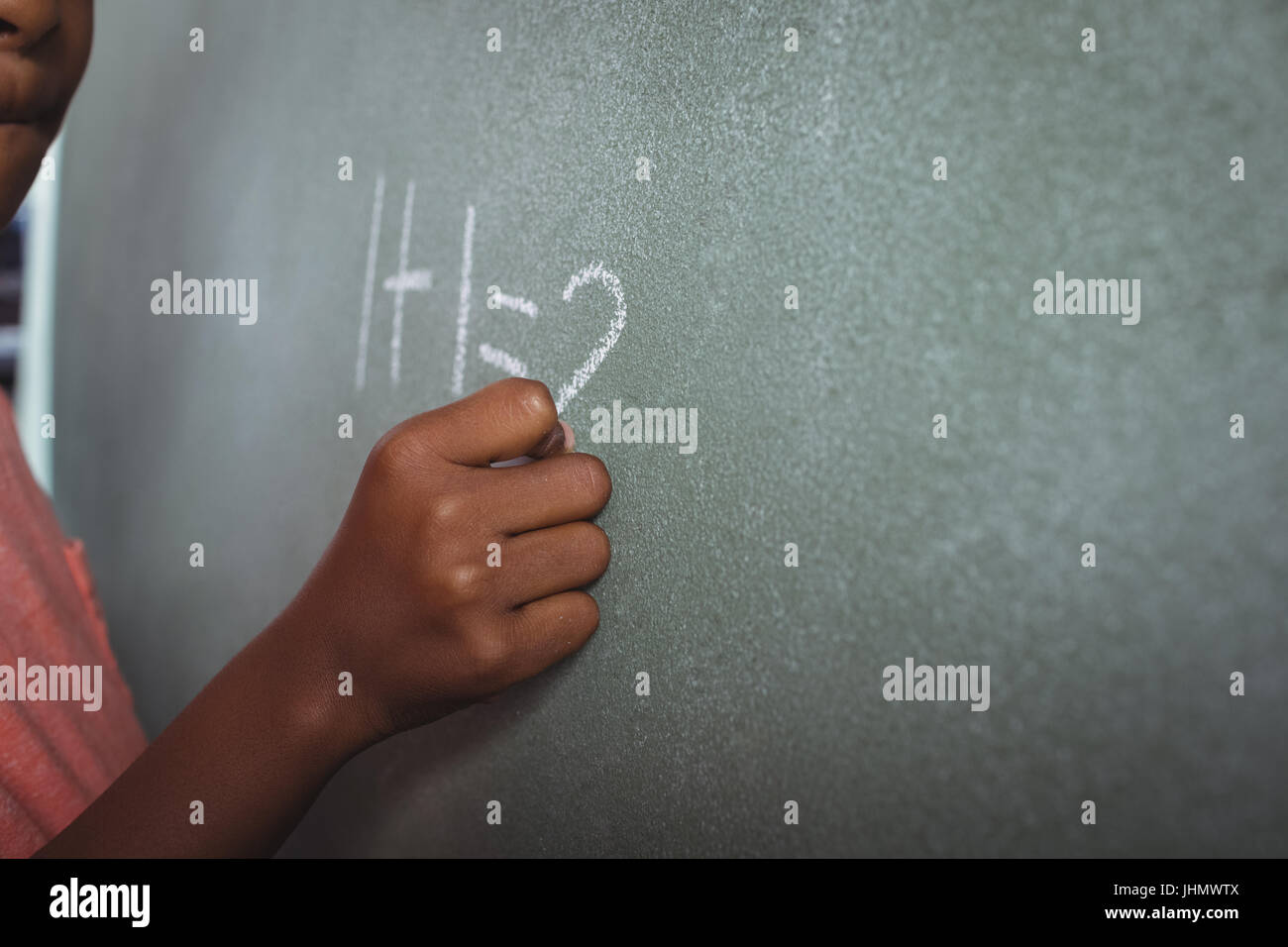 Cropped image of student writing on blackboard in classroom Stock Photo ...
