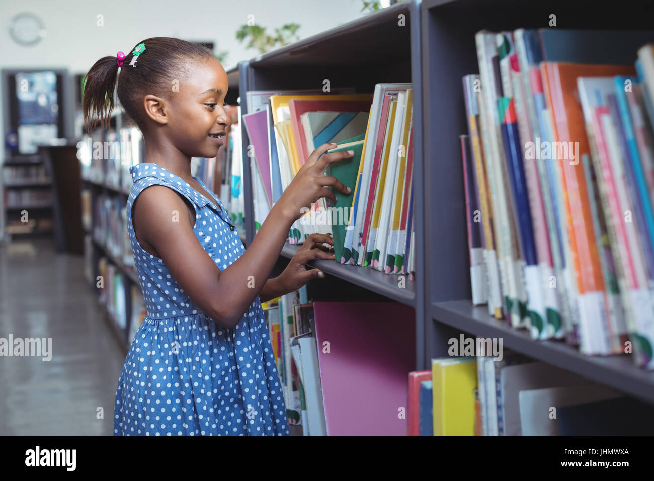 Girl selecting book from bookshelf hi-res stock photography and images ...