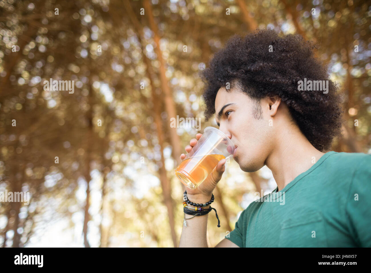 Hand holding drink against trees hi-res stock photography and images ...