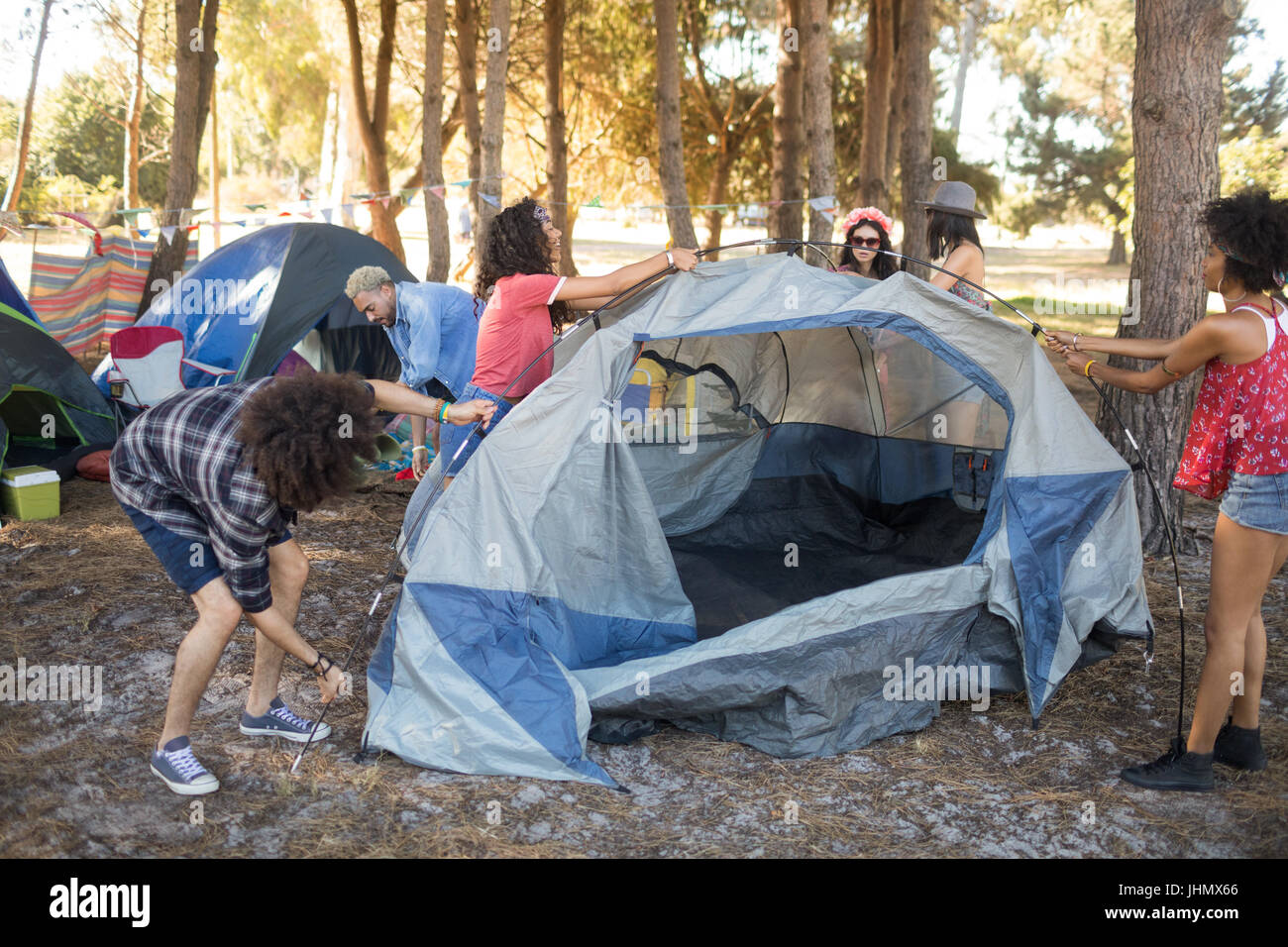 Young friends setting up tents on field at countryside Stock Photo - Alamy