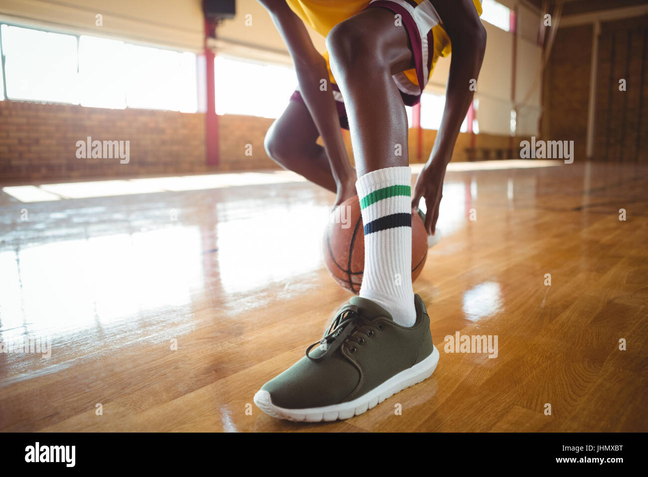 Low section of teenage boy practicing basketball in court Stock Photo ...