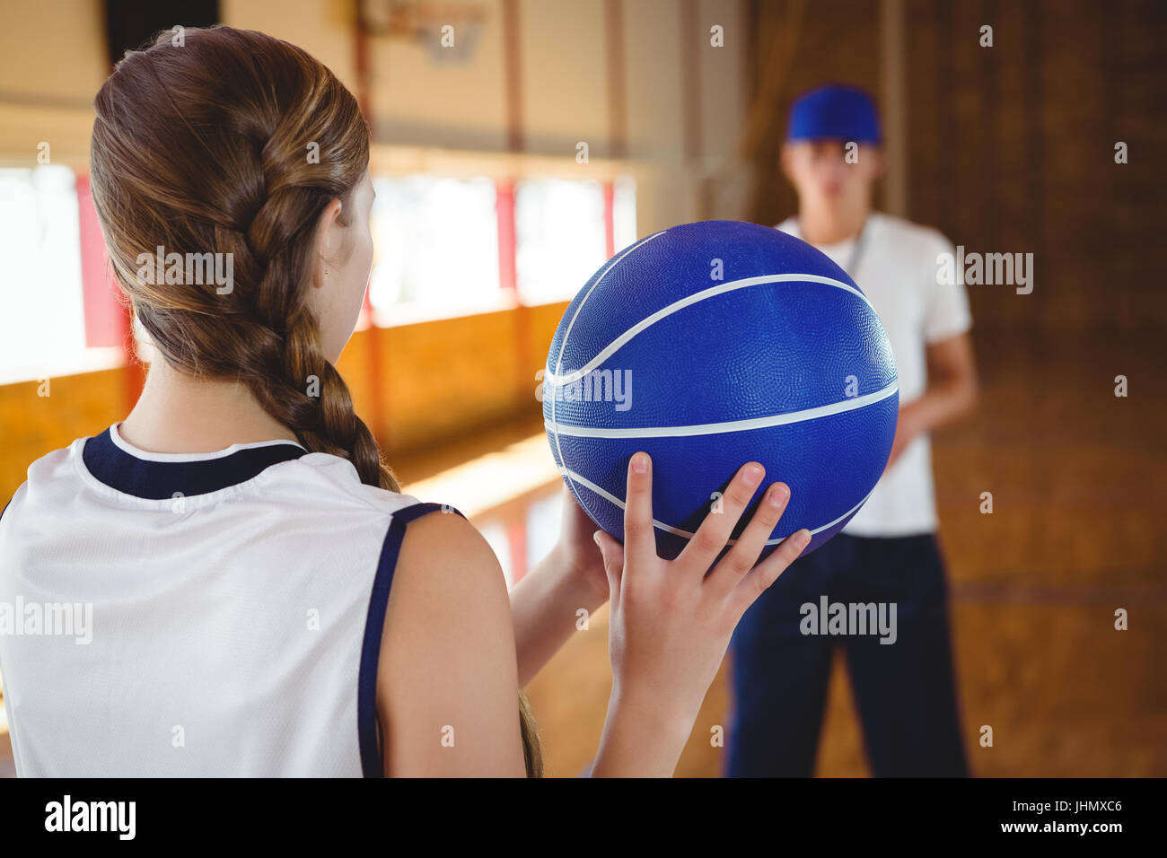 Female basketball player practicing with male coach in court Stock ...