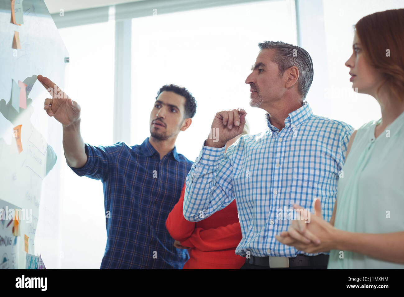 Serious business people discussing over whiteboard at office Stock ...