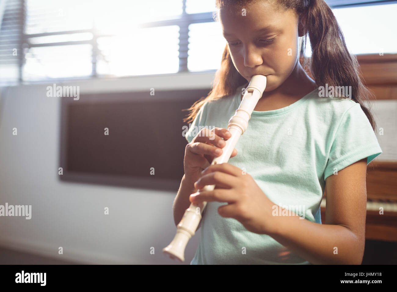Girl practicing flute in classroom at music school Stock Photo - Alamy