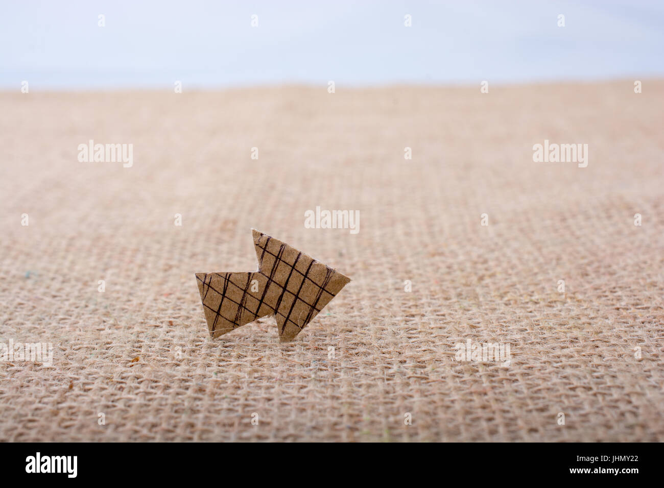 Arrow sign cut out of brown paper on canvas Stock Photo - Alamy