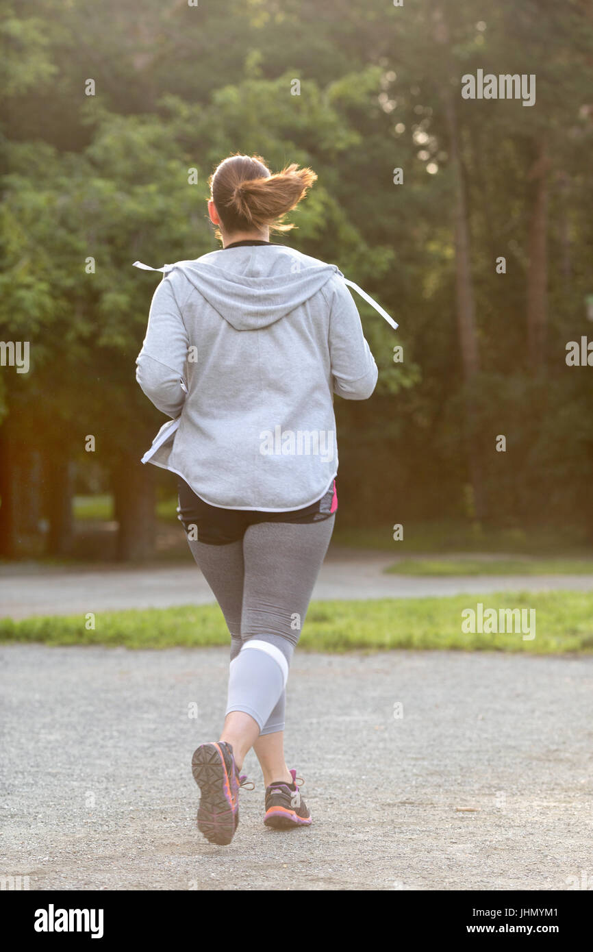 Overweight woman back running in the park . Weight loss concept Stock ...