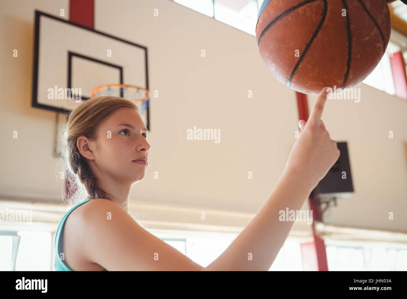 Side view of basketball player balancing ball on finger while ...