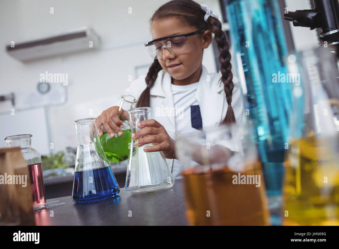 Elementary student doing scientific experiment at science laboratory ...