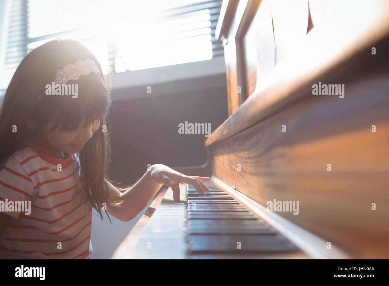 Elementary girl practicing piano in class at music school Stock Photo ...