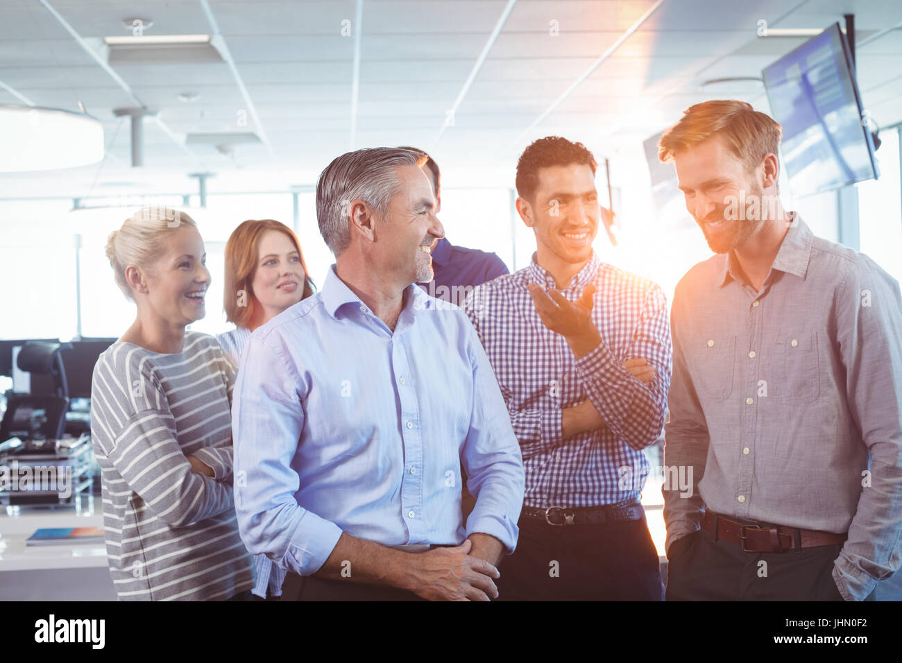 Happy business colleagues standing at office Stock Photo - Alamy