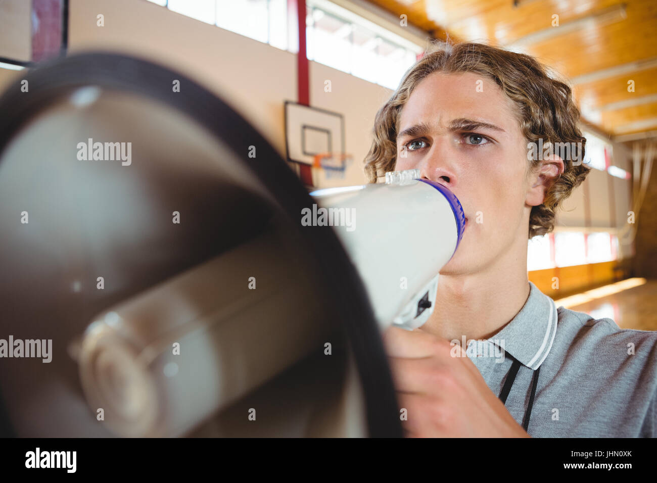 Male coach using megaphone in basketball court Stock Photo - Alamy