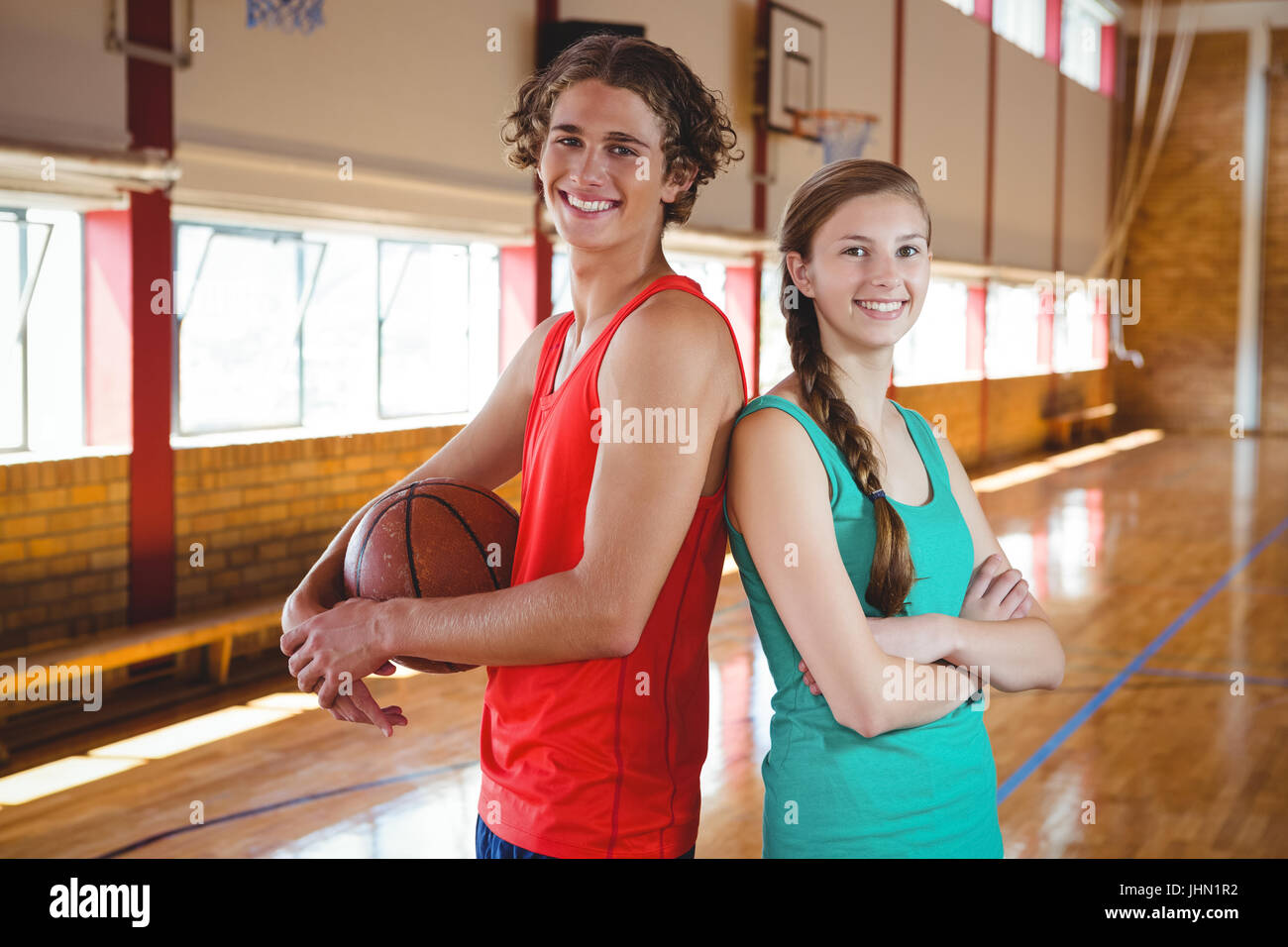 Portrait of basketball players standing back to back in court Stock ...