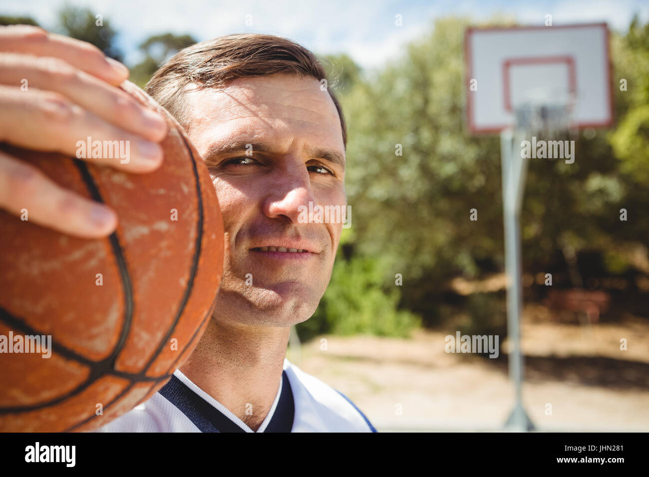 Close up portrait of confident basketball player with ball standing in ...