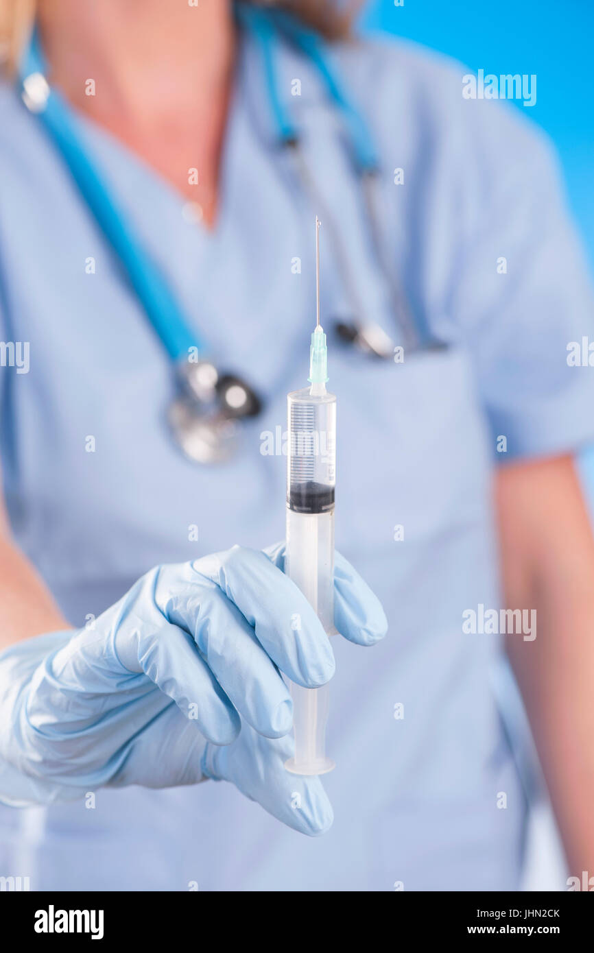 Doctor holding medical injection syringe and stethoscope Stock Photo ...