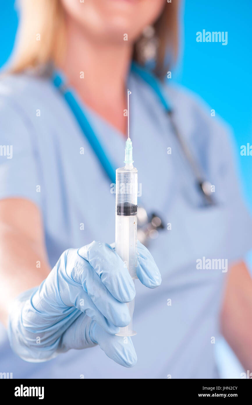 Doctor holding medical injection syringe and stethoscope Stock Photo ...