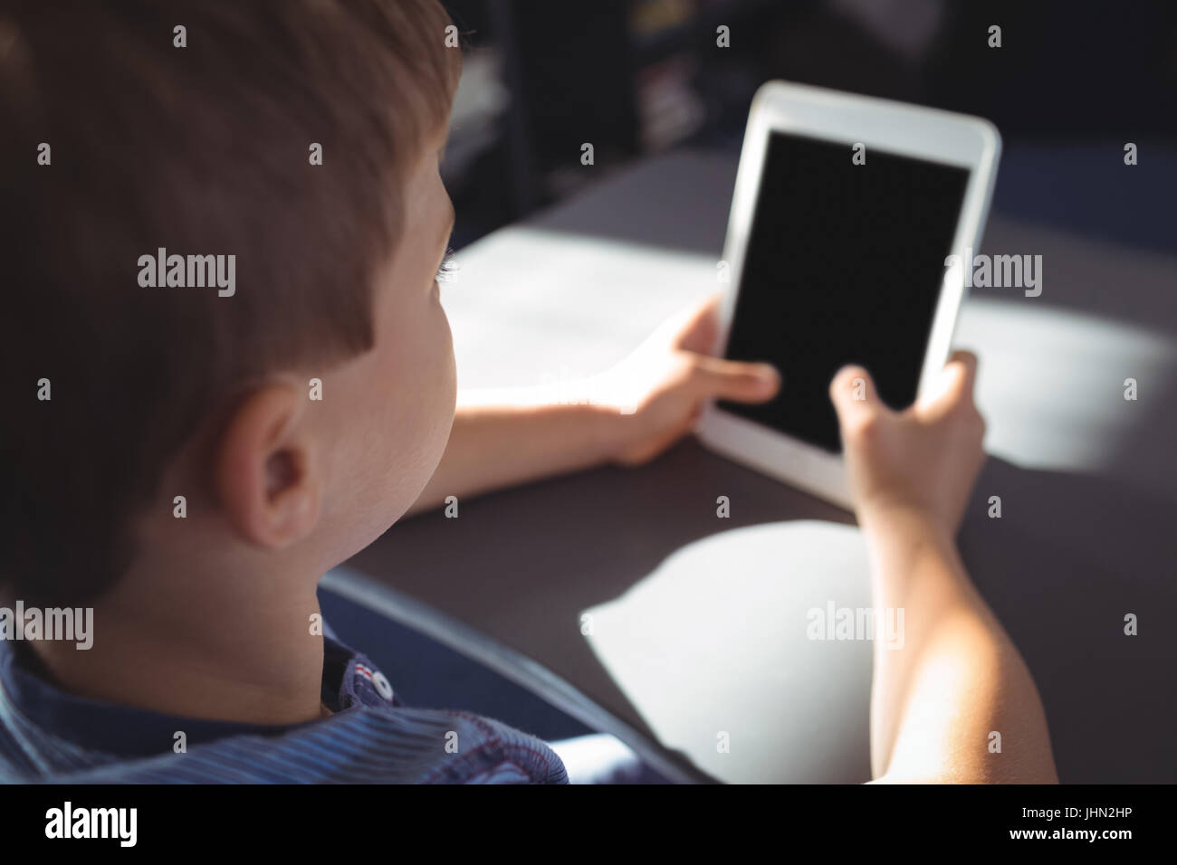 High angle view of boy using digital tablet at desk Stock Photo - Alamy