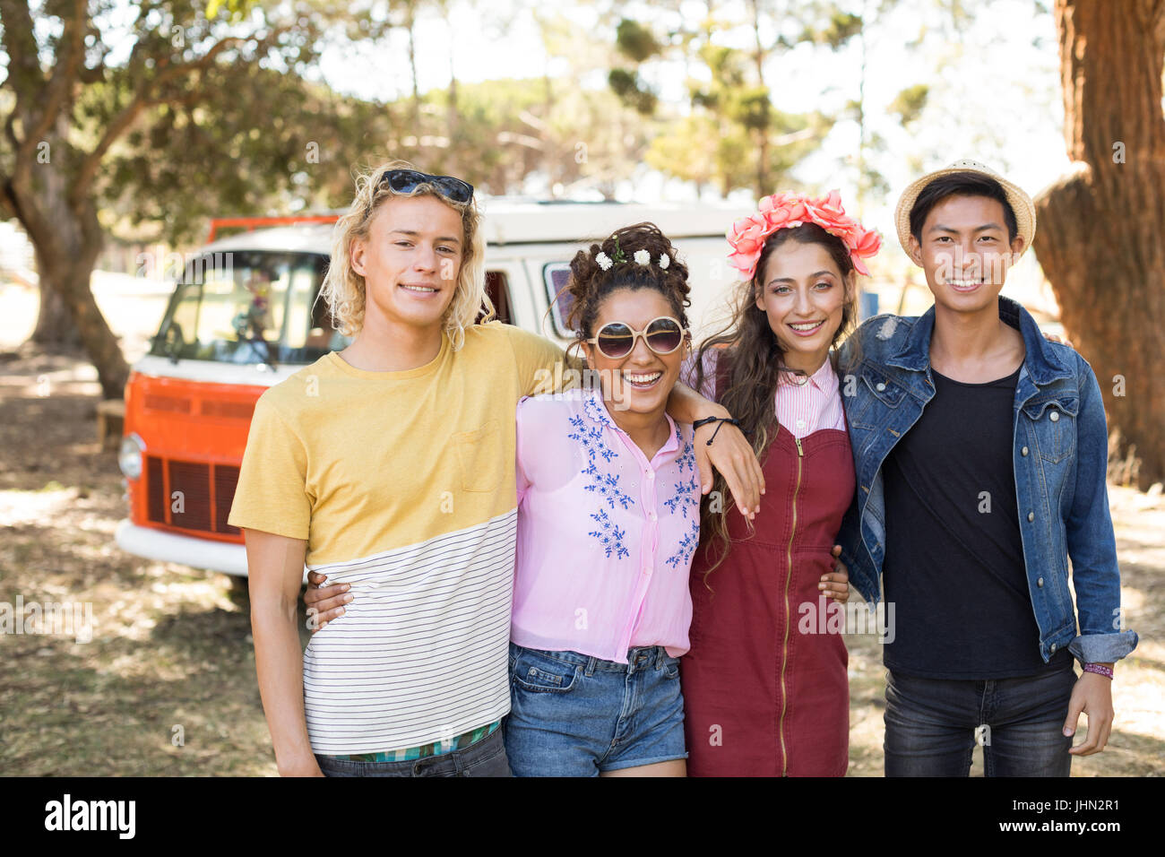 Portrait of smiling friends standing on field Stock Photo - Alamy