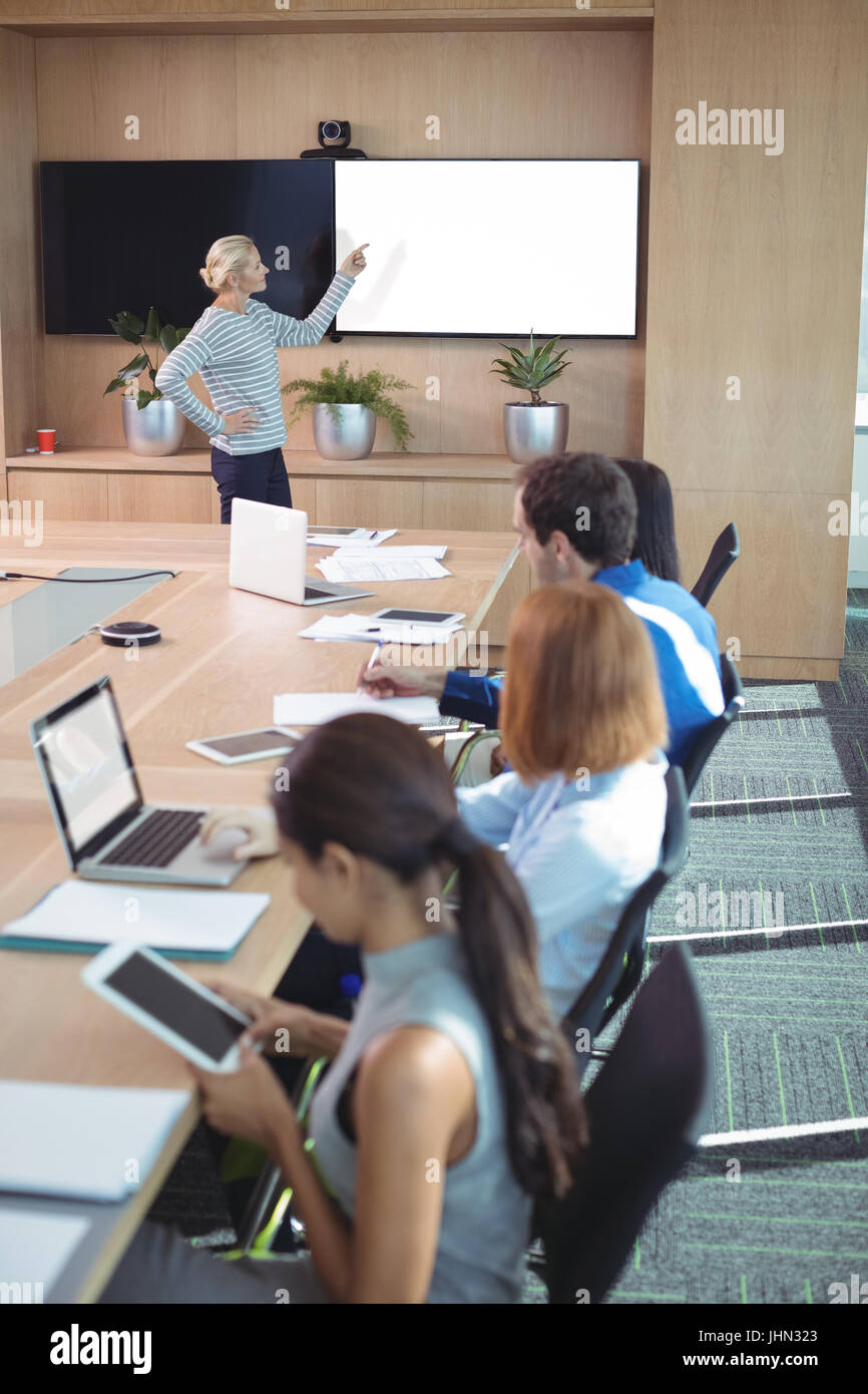 Colleagues at conference table during business meeting in board room ...