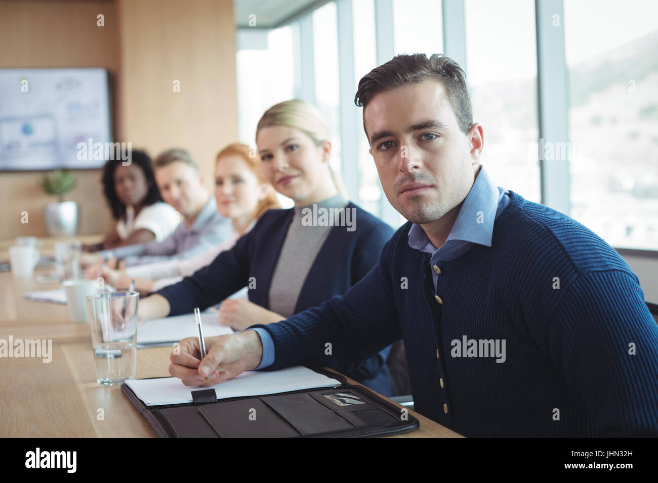 Portrait of business people sitting at desk in office Stock Photo - Alamy