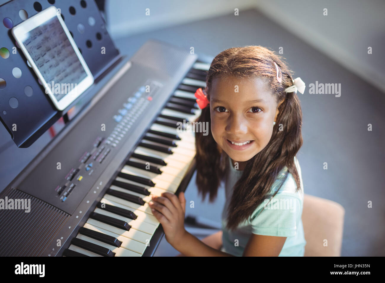 Portrait of elementary girl practicing piano in class at school Stock ...