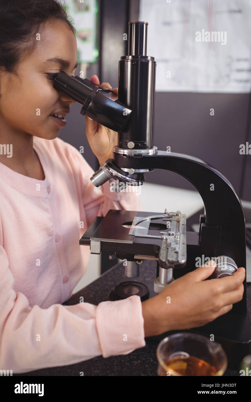 Elementary student using microscope on desk at science laboratory Stock ...