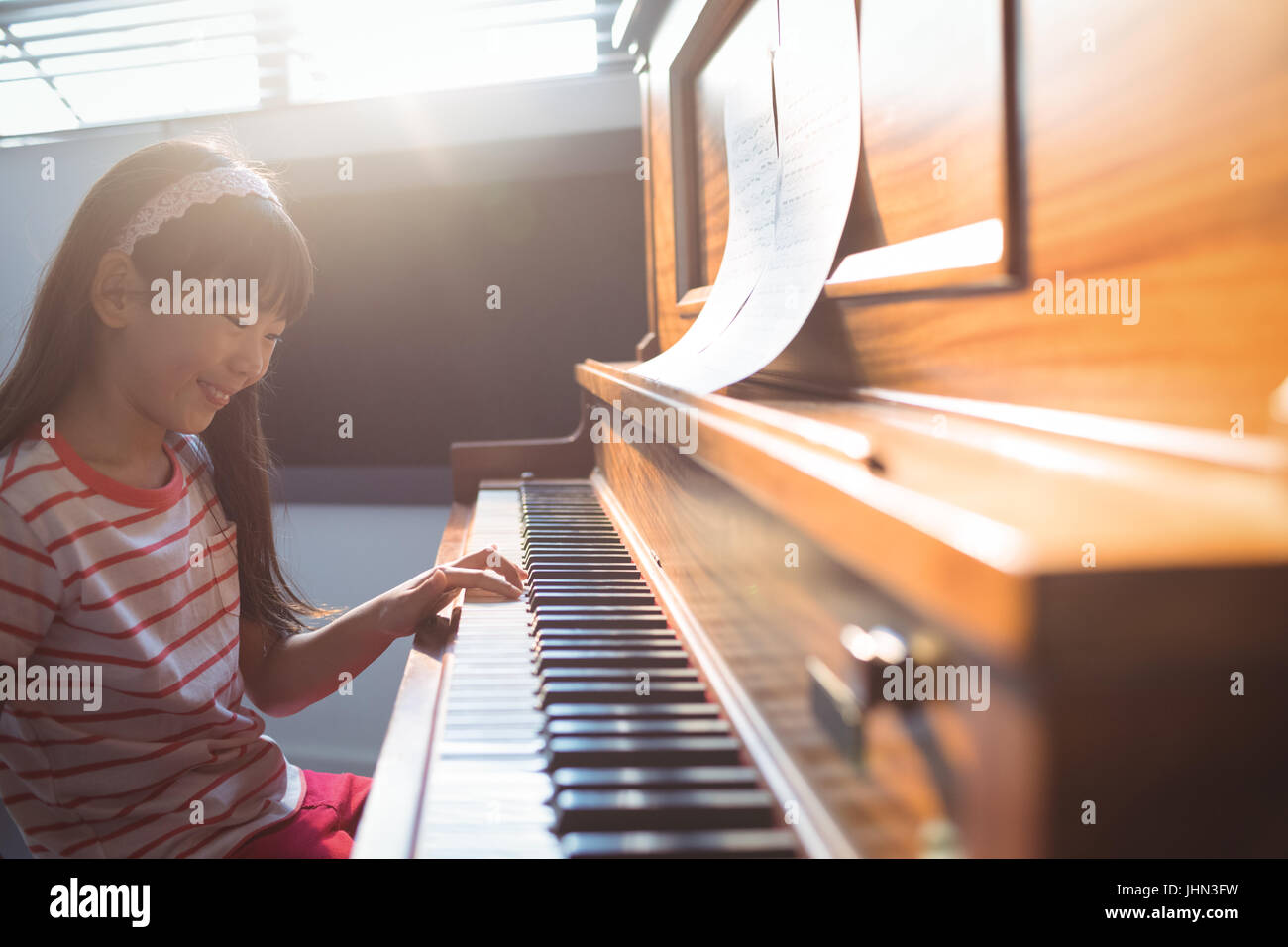 Smiling girl practicing piano in class at music school Stock Photo - Alamy