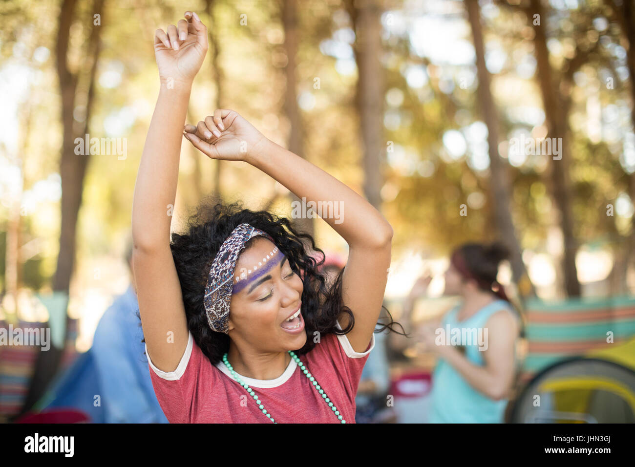 Happy woman dancing with arms raised at campsite Stock Photo - Alamy