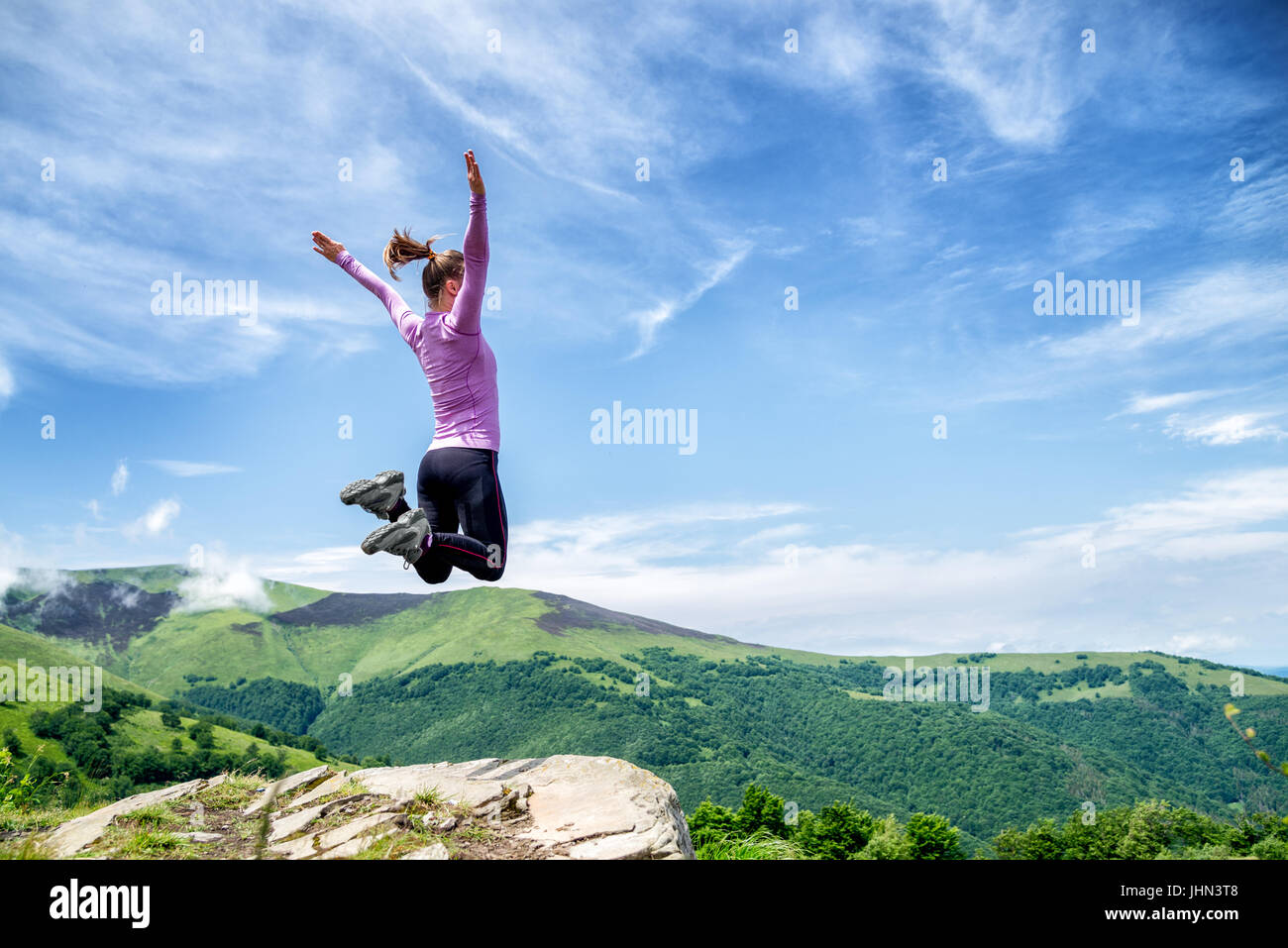 Young woman jumping in the mountains Stock Photo - Alamy