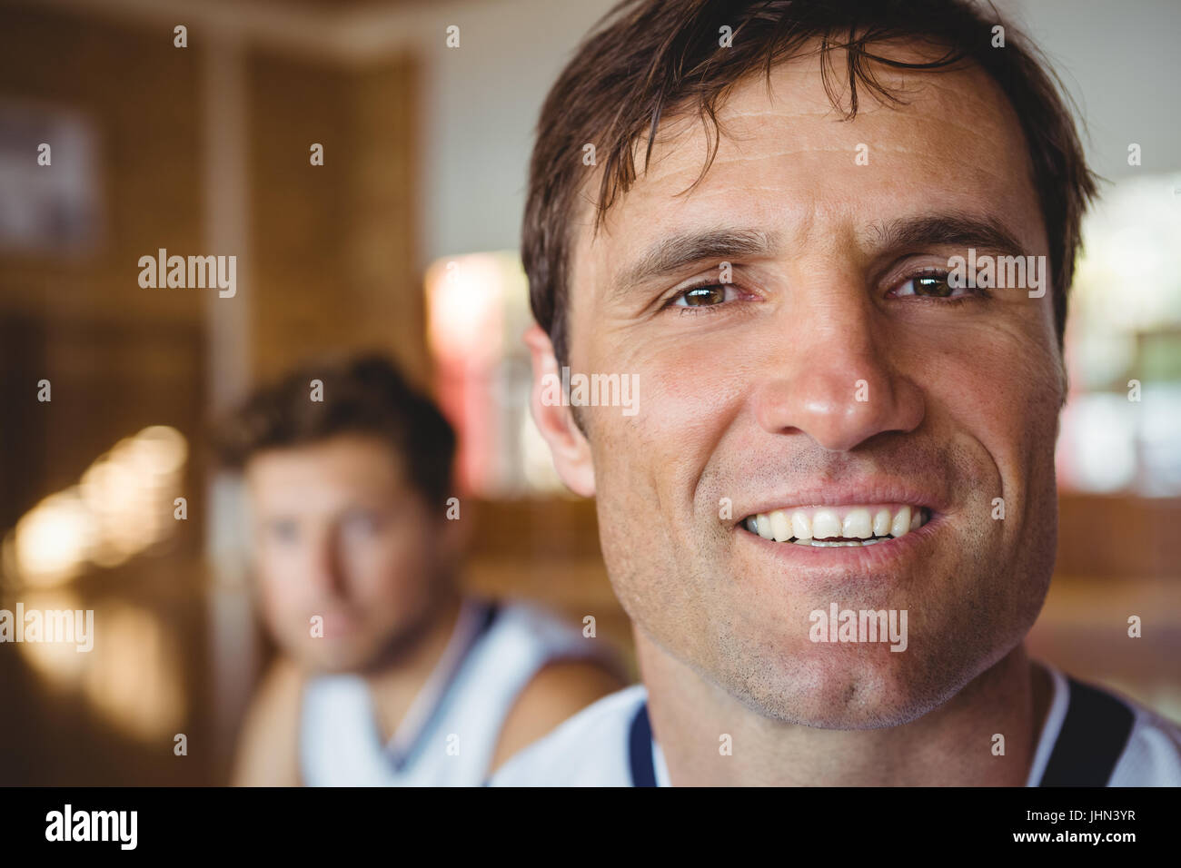 Close up portrait of smiling basketball player with friend in ...
