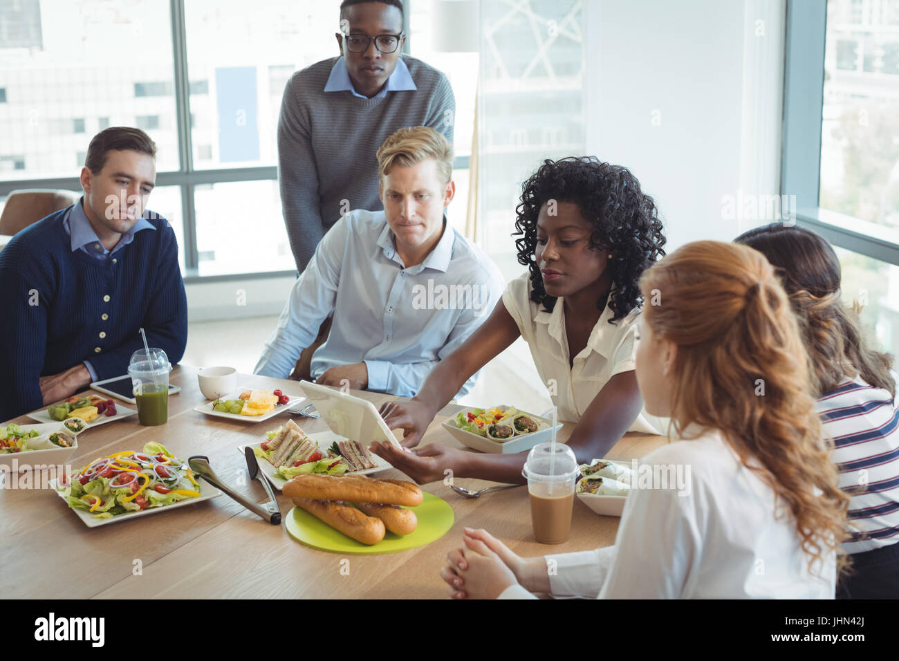 Serious business colleagues discussing while sitting around breakfast ...