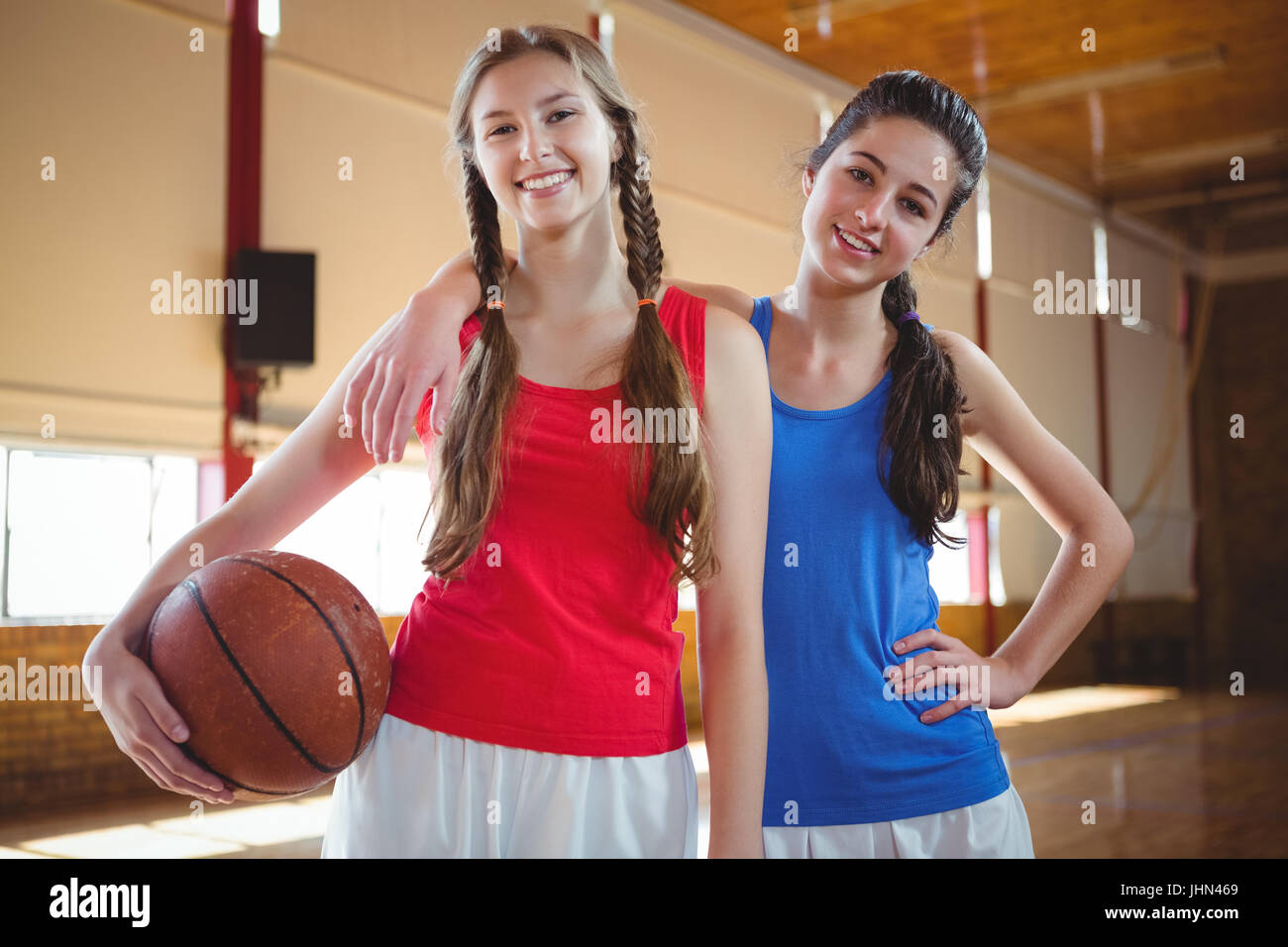 Portrait of happy female basketball players standing in court Stock ...