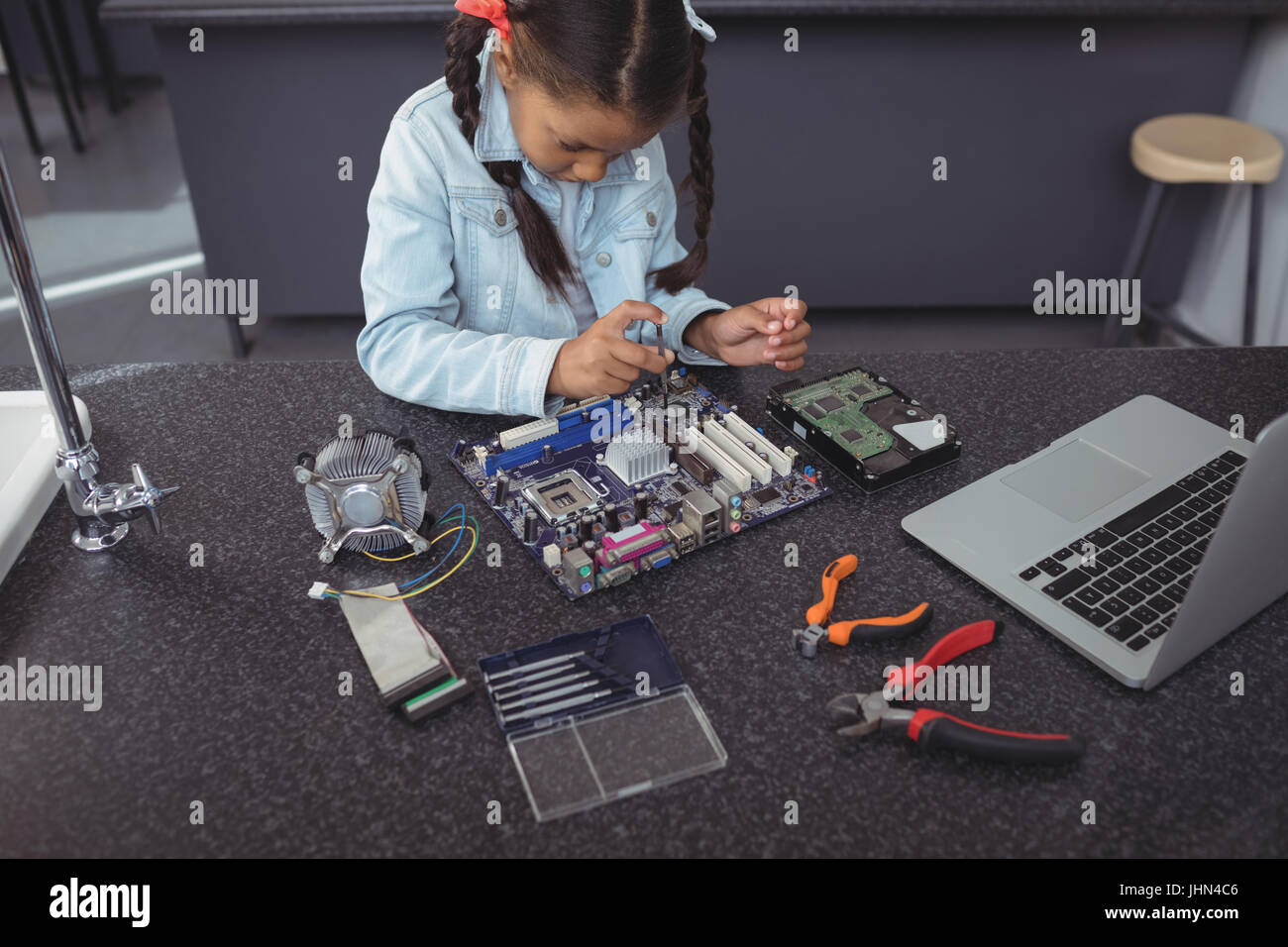 High angle view of concentrated elementary girl assembling circuit ...