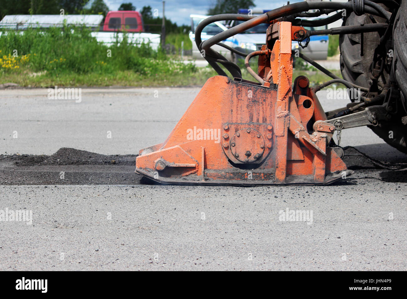 A tractor with a nozzle repairs the road. Patch repair to pits Stock ...