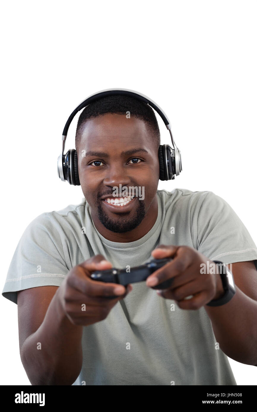 Smiling man playing video game against white background Stock Photo - Alamy