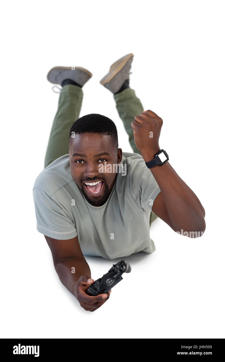 Excited man playing video games against white background Stock Photo ...