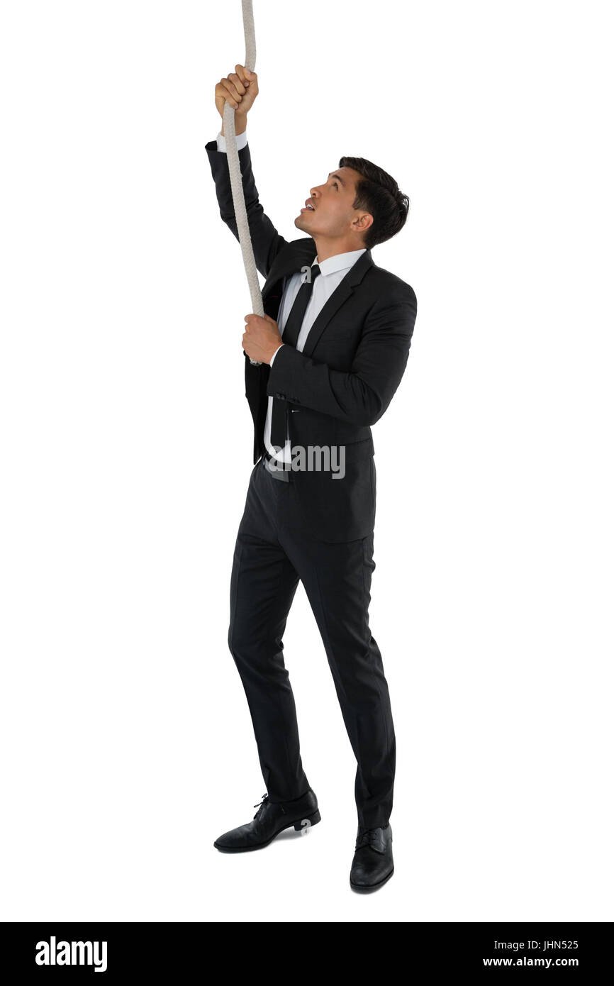 Businessman pulling rope while standing against white background Stock ...