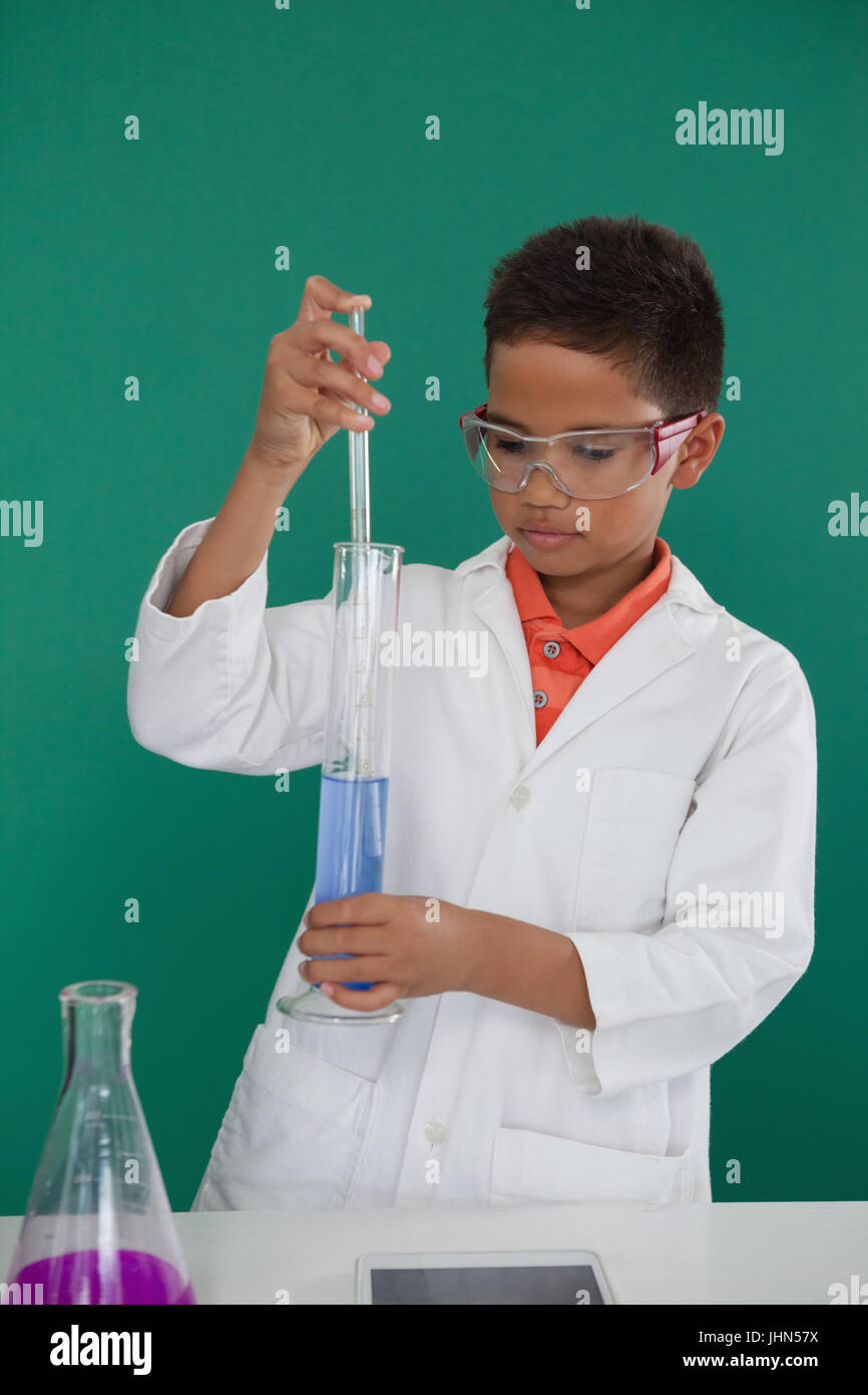 Attentive schoolboy doing a chemical experiment in laboratory at school ...